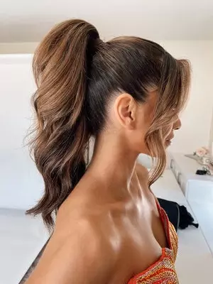 Brunette hier styled yn in fluffige, golvende ponytail.