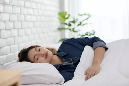 Uma mulher dorme. O ruído branco demonstrou ser útil para o sono em algumas situações. No entanto, res...