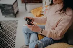 Jeune femme jouant aux meilleurs jeux vidéo des années 90 à la maison.