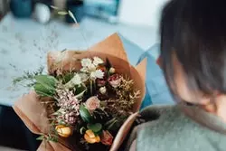 Hoge hoekmening van jonge vrouw met vers bloemboeket. Valentijnsdag. Bloemen levering.