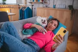 Une jeune femme prend un selfie avec son chien sur le canapé. Pouvez-vous dire si quelqu'un refuse votre DM sur i...